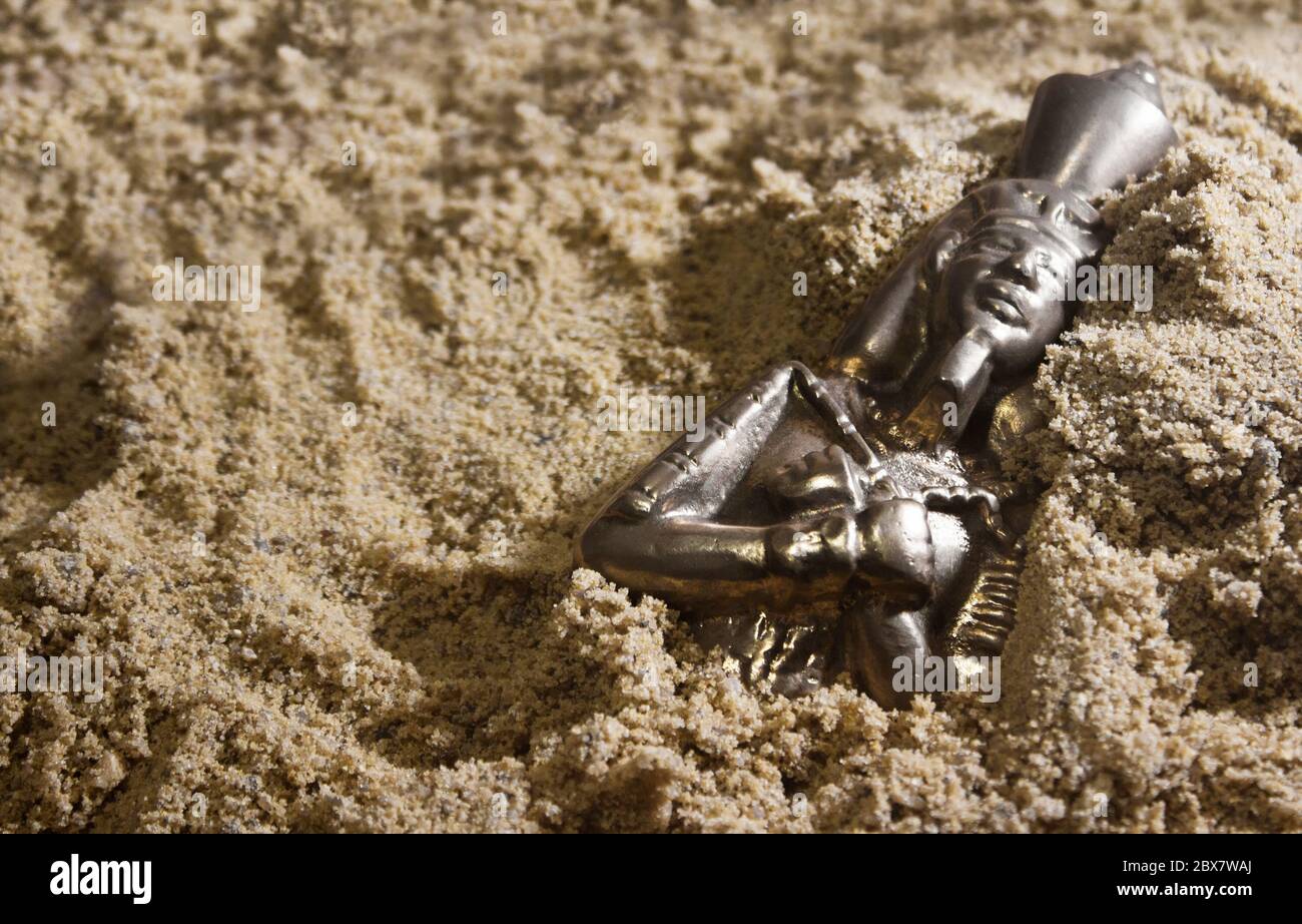 Old ancient metal pharaoh statuette laying in sand Stock Photo - Alamy