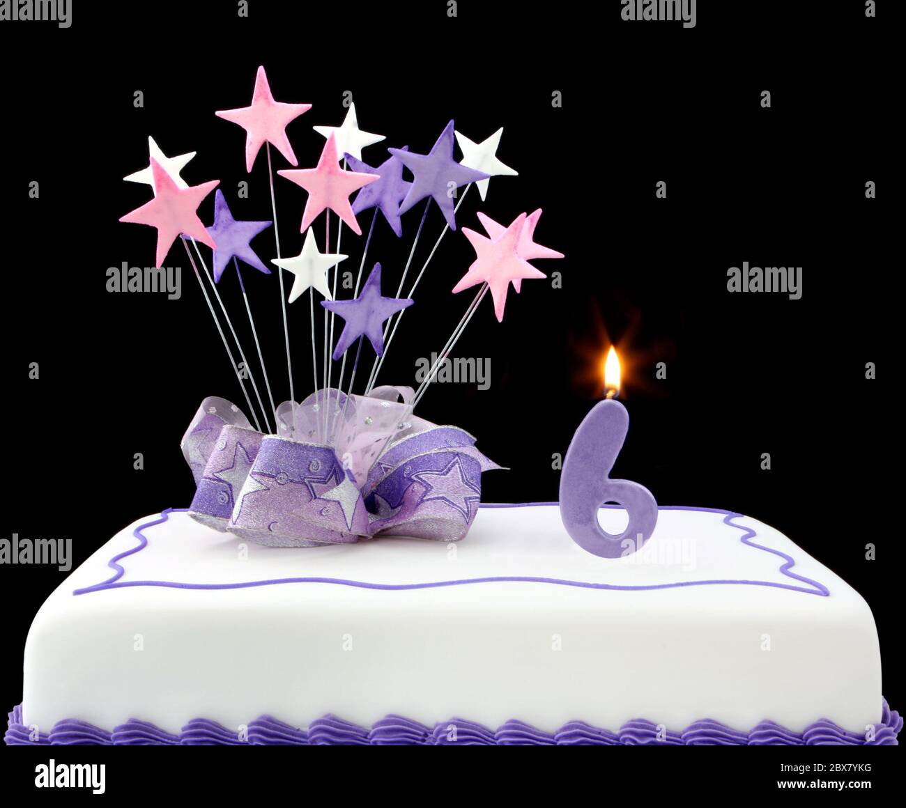 Fancy cake with number 6 candle. Decorated with ribbons and star-shapes ...