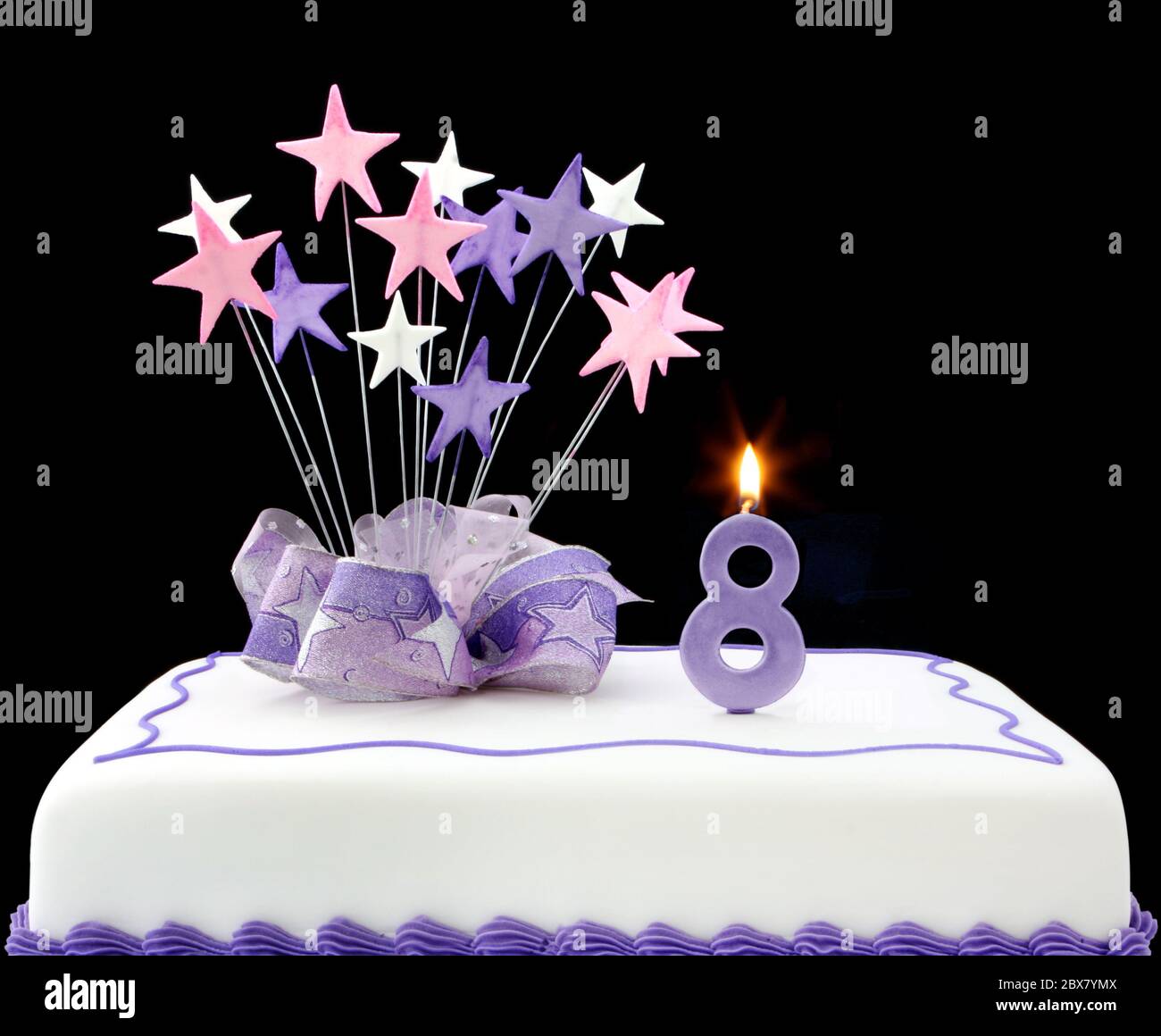 Fancy cake with number 8 candle. Decorated with ribbons and star-shapes ...