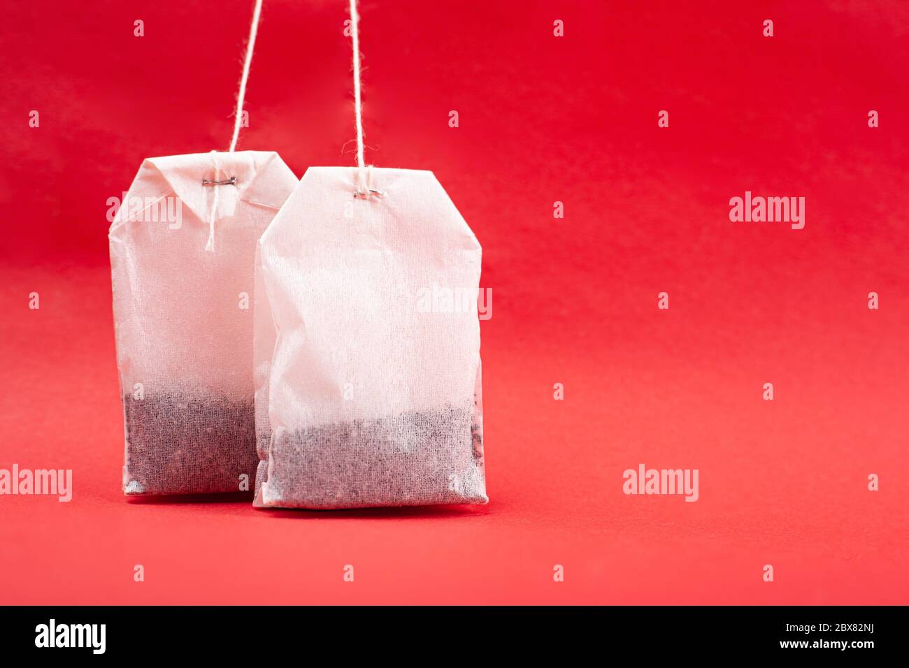 paper white tea bags with copy space on a red background, mockup Stock ...