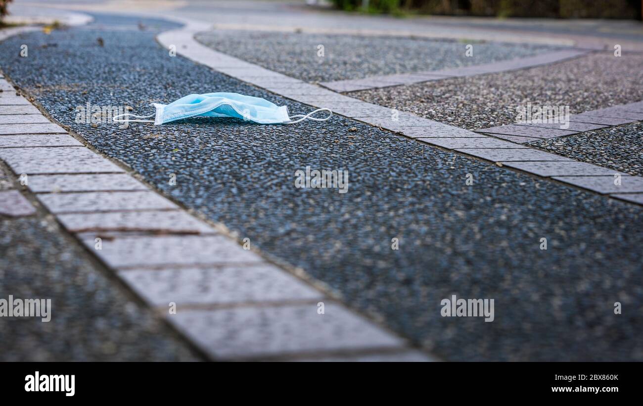 Medical face mask fall to the ground in street. Improperly discarding ...