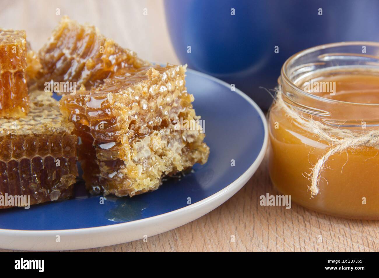 Pieces of golden honey comb on a table with tea, lemon and cinnamon ...