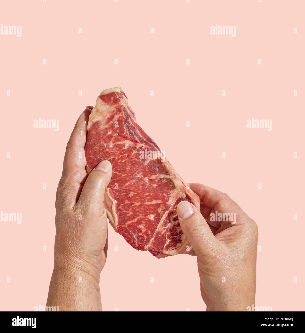 fresh raw steak in human hand isolated on pink background Stock Photo ...
