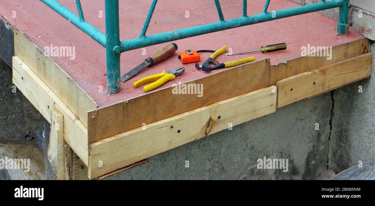 Handmade repair of the destroyed concrete porch in a poor rural house ...