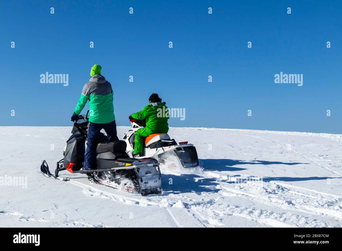 Rider on the snowmobile in the mountains ski resort. A man is riding ...