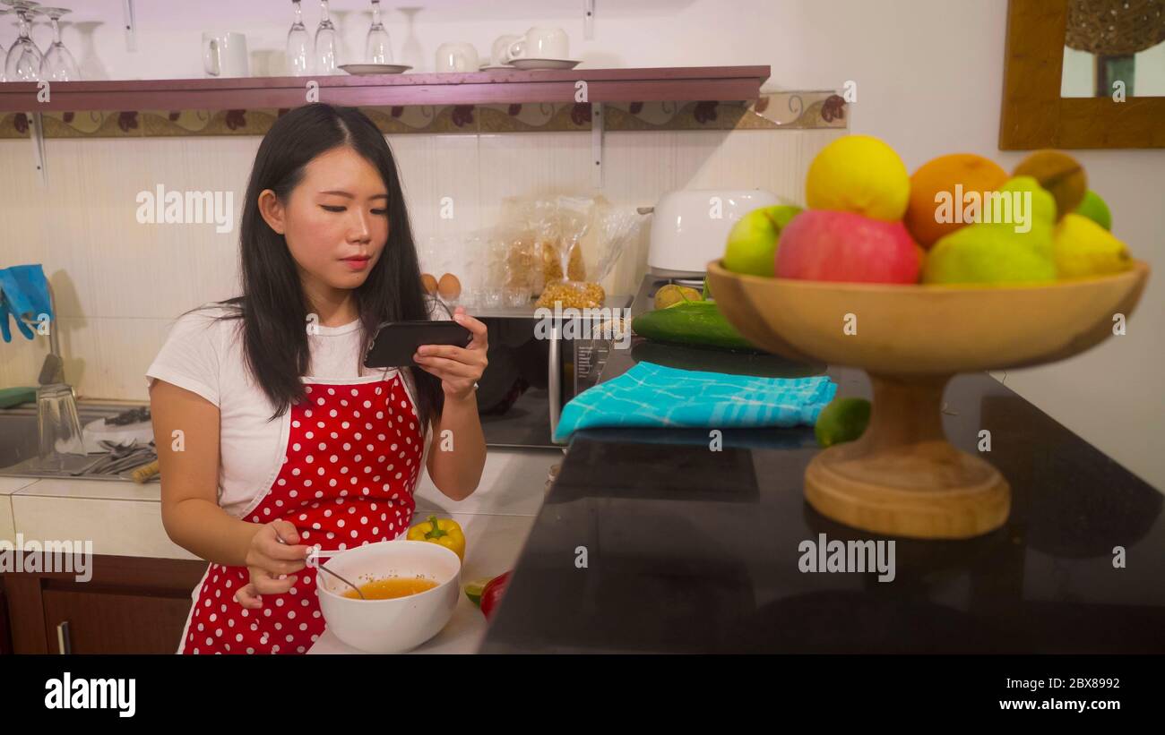 cheerful domestic cooking - young happy and beautiful Asian Korean home ...