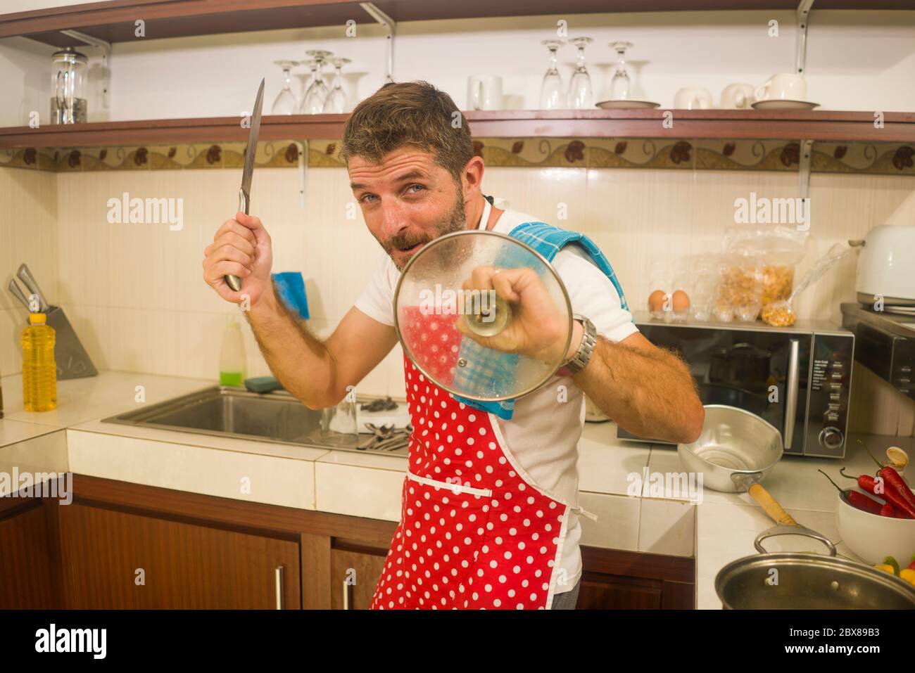 funny domestic portrait of silly and happy home cook man in cooking ...
