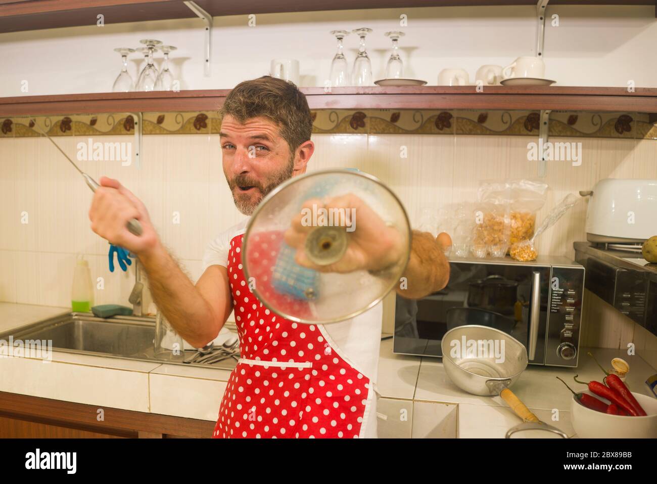 funny domestic portrait of silly and happy home cook man in cooking ...
