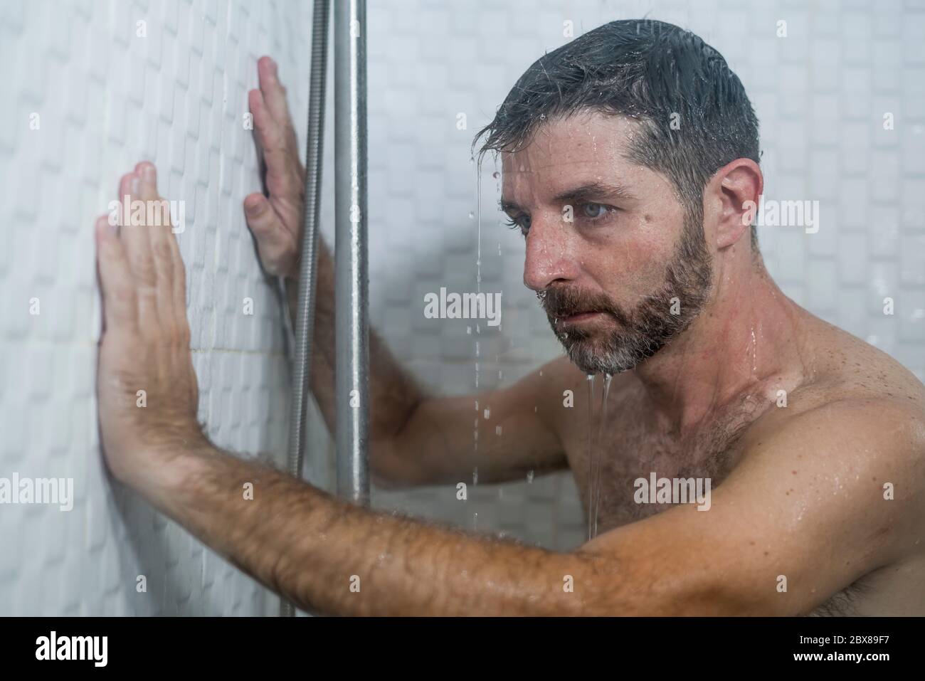 home bathroom dramatic shot of young attractive sad and depressed man ...
