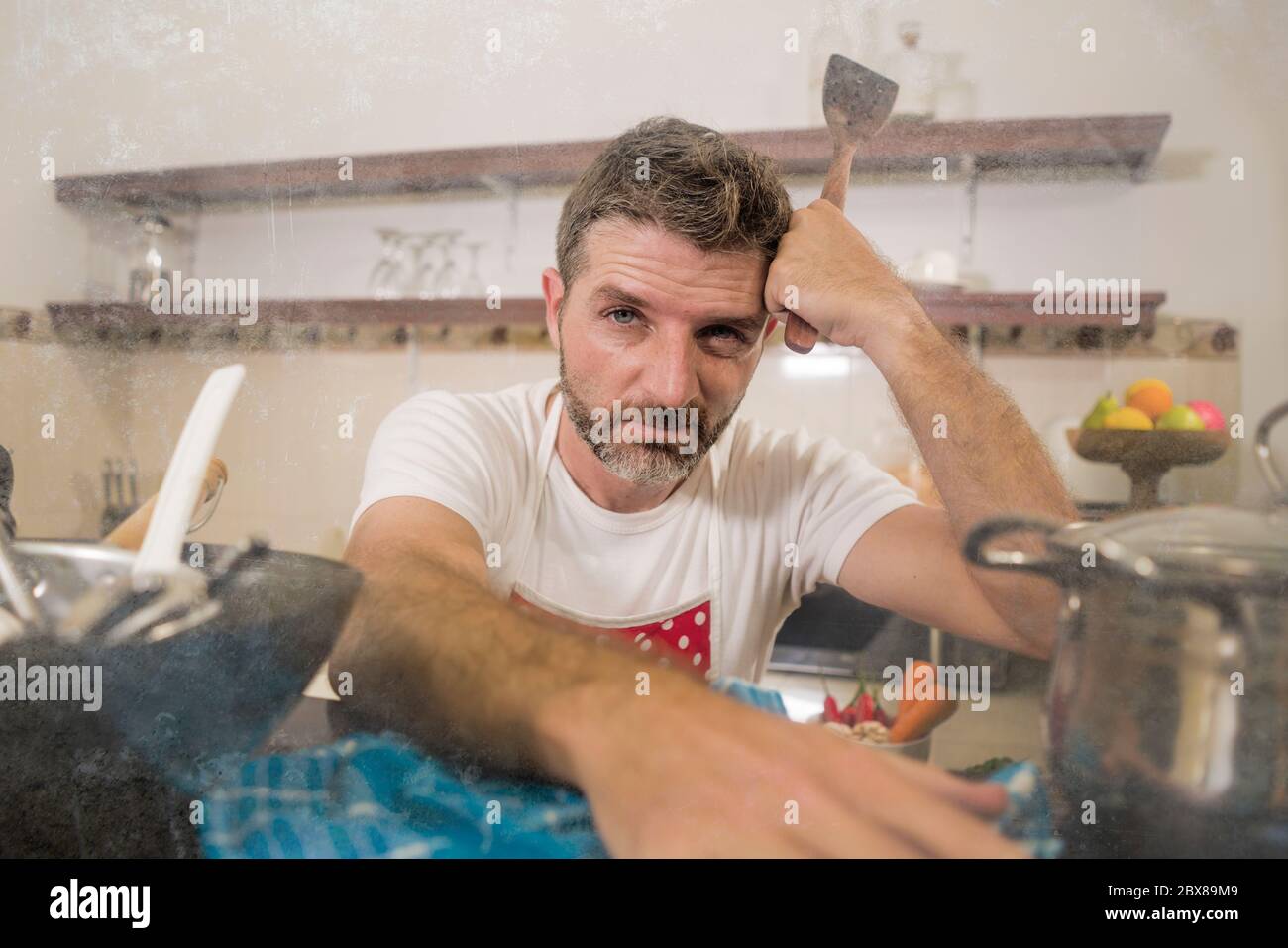 domestic chores stress - young attractive overworked and depressed man ...