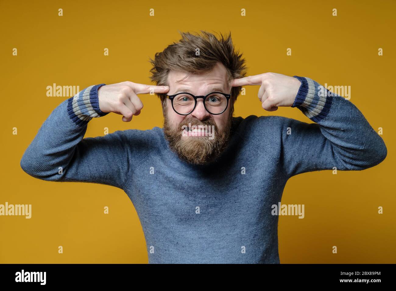 Angry shaggy man with glasses and an old sweater holds index fingers on ...