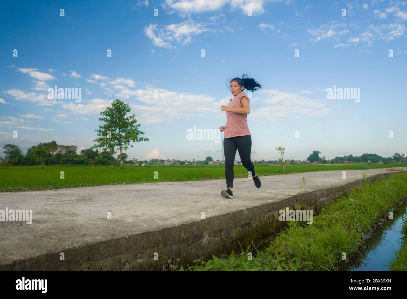 outdoors jogging workout - young happy and dedicated Asian Korean woman ...