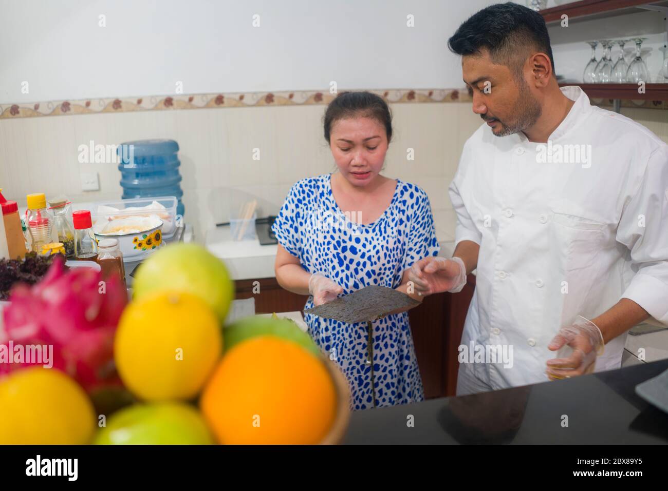 happy Asian couple cooking together - home kitchen lifestyle portrait ...