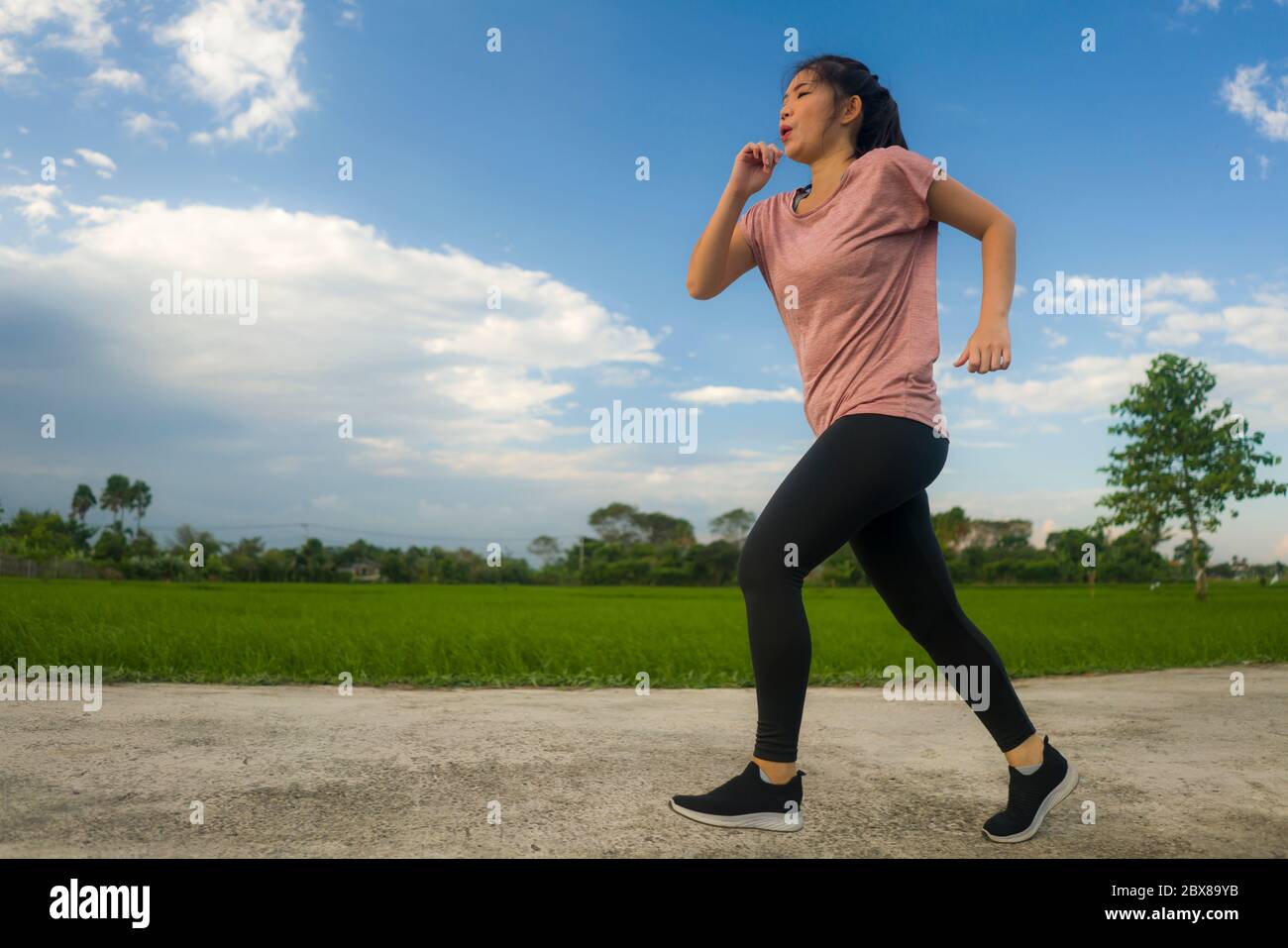 outdoors jogging workout - young happy and dedicated Asian Korean woman ...