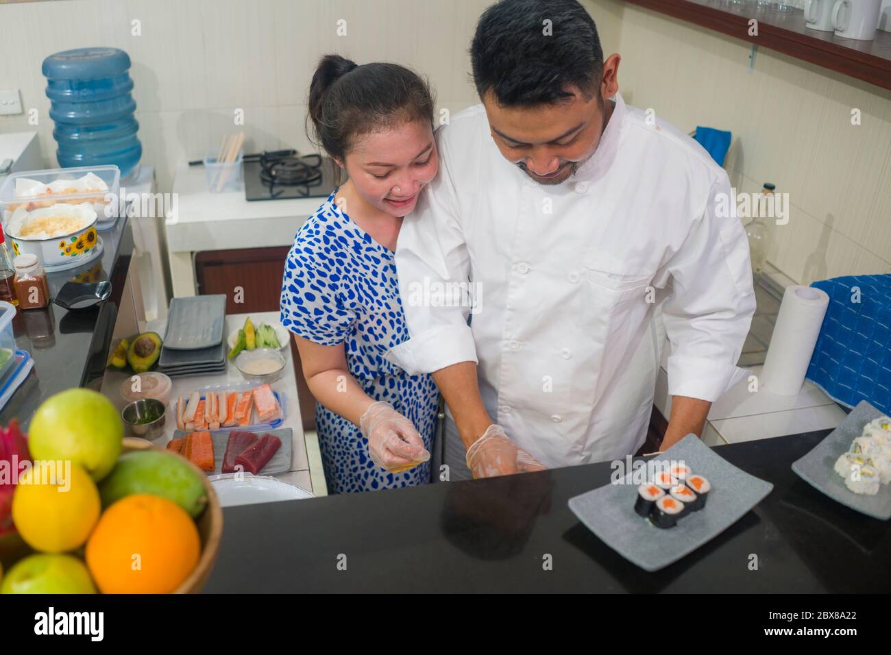 happy Asian couple cooking together - home kitchen lifestyle portrait ...