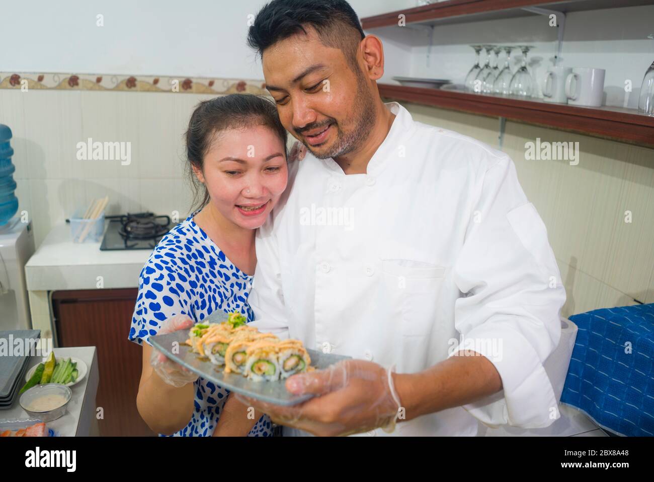 happy Asian couple cooking together - home kitchen lifestyle portrait ...