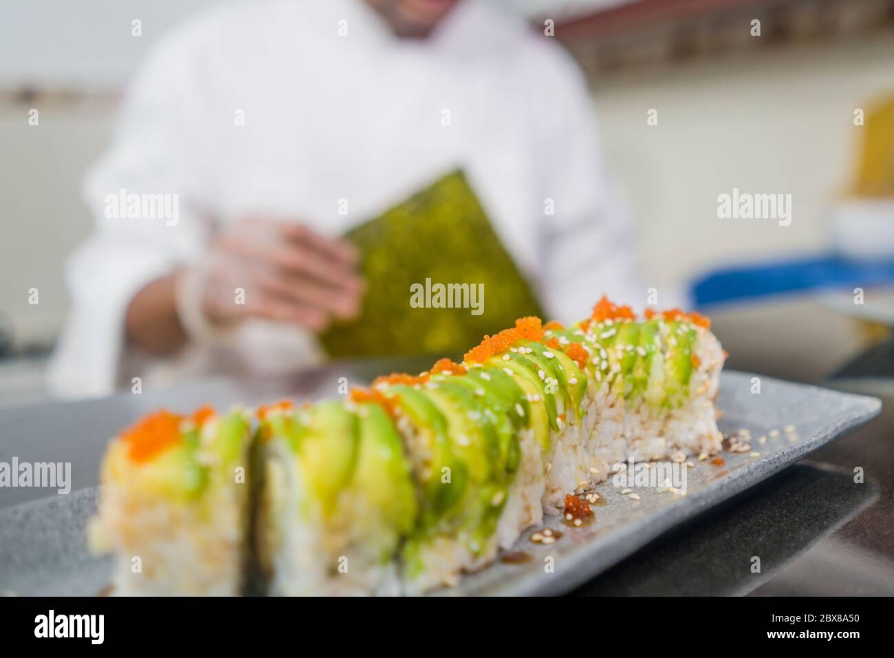 hands in gloves of Asian professional chef preparing delicious and ...