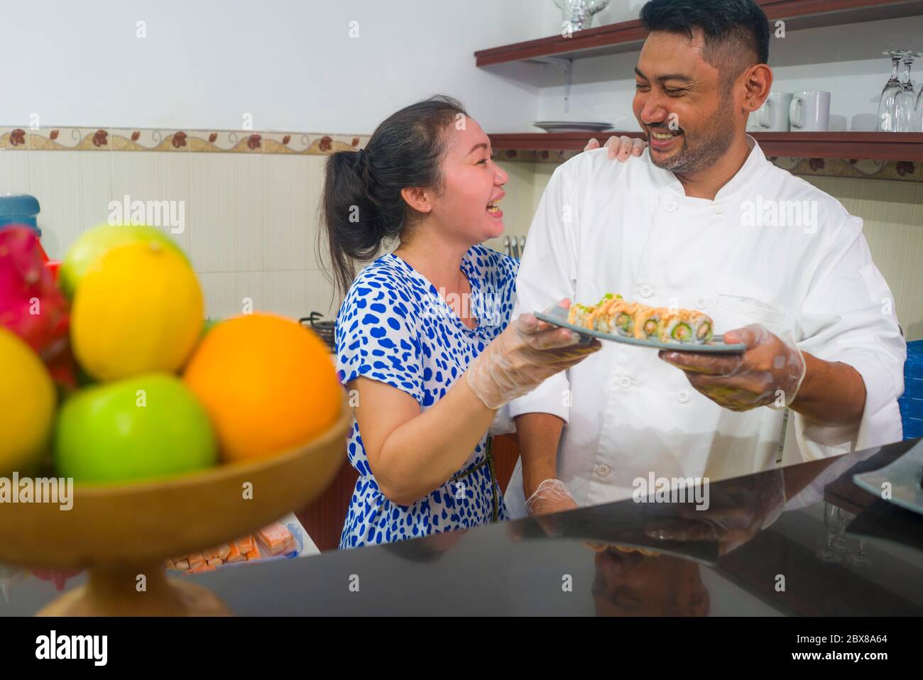 happy Asian couple cooking together - home kitchen lifestyle portrait ...