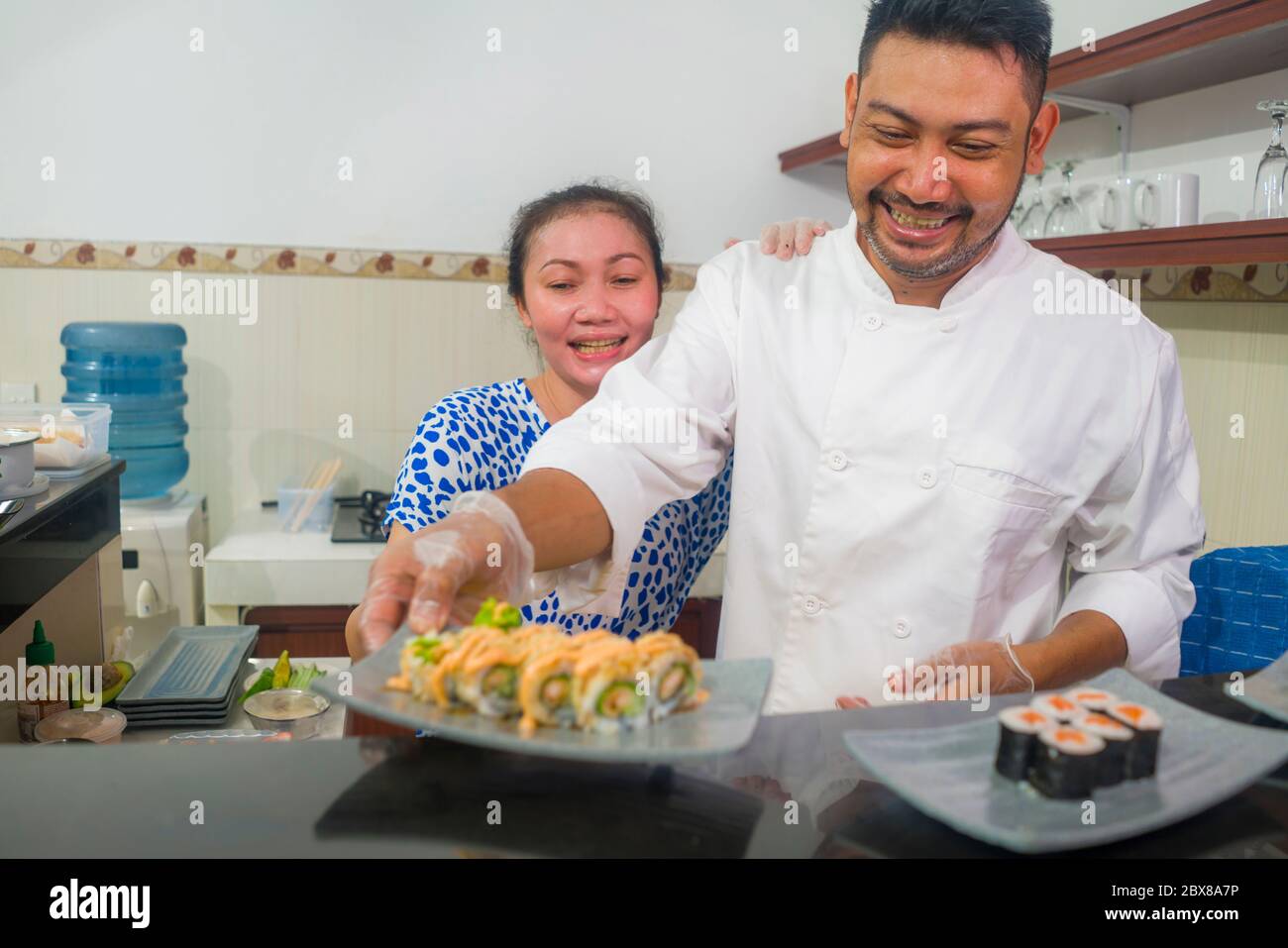 happy Asian couple cooking together - home kitchen lifestyle portrait ...