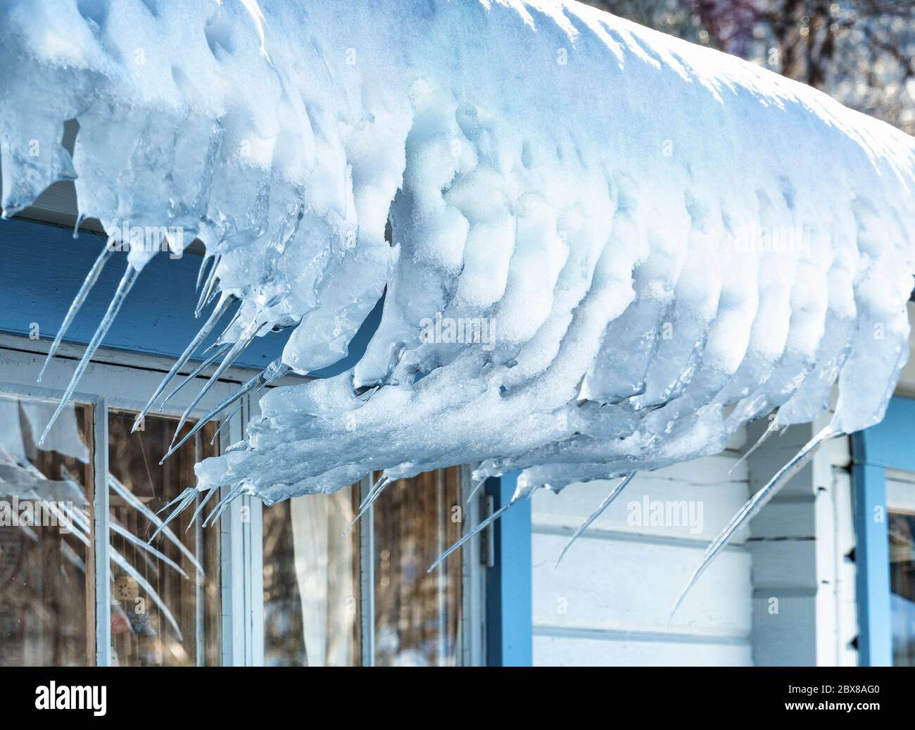 Close up photo of snow and bent icicles hanging from the roof of ...