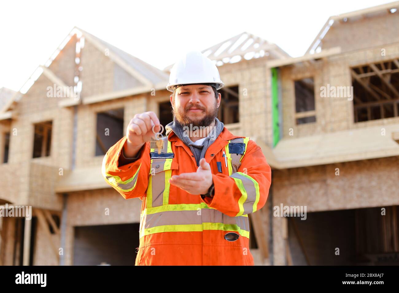 Portrait of caucasian engineer giving keys from new house Stock Photo ...