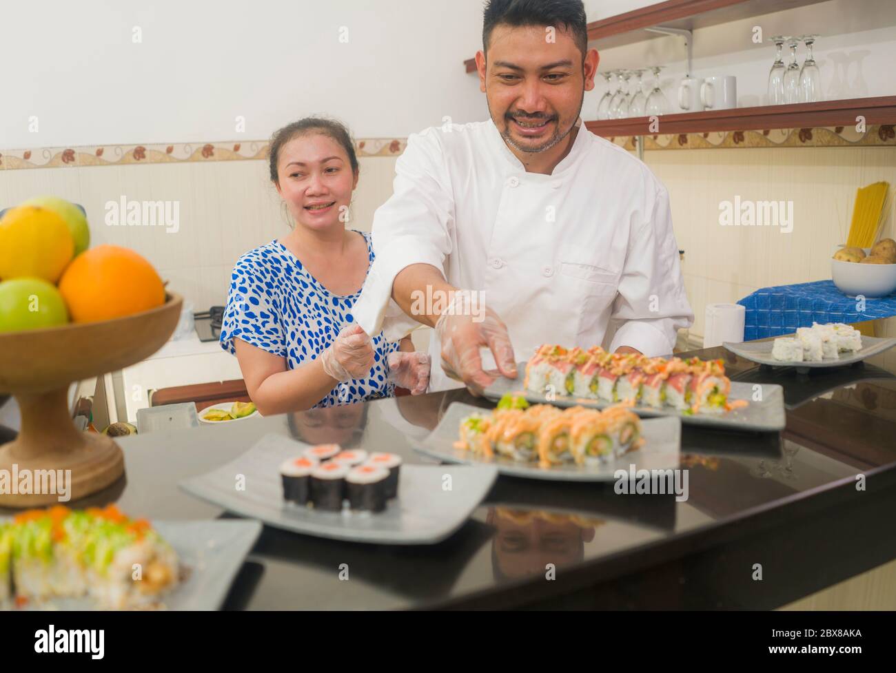 happy Asian couple cooking together - home kitchen lifestyle portrait ...
