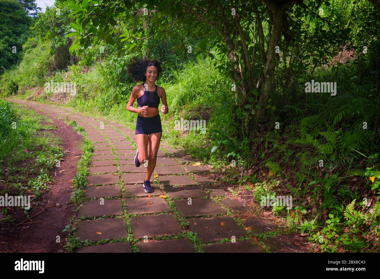 happy female runner training on countryside road - young attractive and ...
