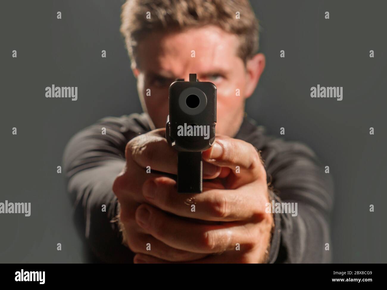 action portrait of serious and attractive hitman or special agent man ...