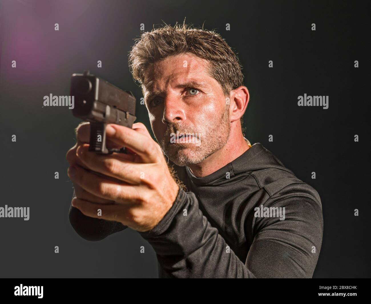 action portrait of serious and attractive hitman or special agent man ...