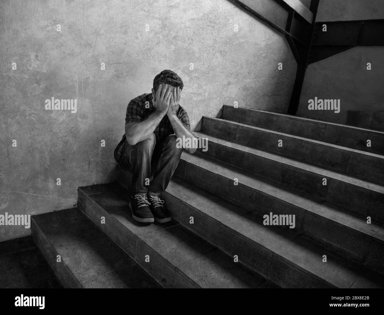 dramatic portrait of young depressed and desperate man sitting outdoors ...