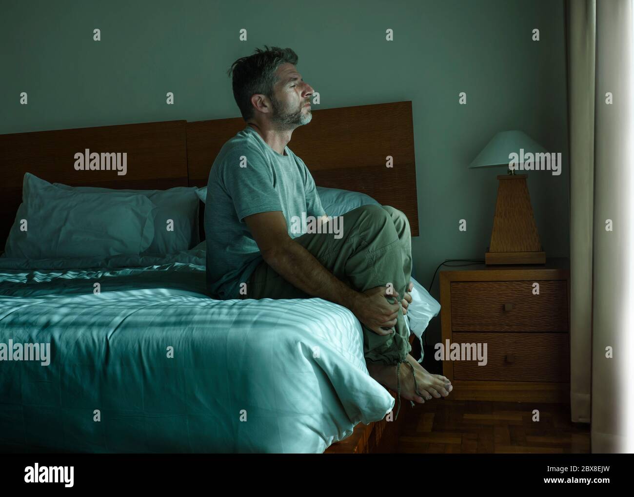 Attractive depressed and upset man thoughtful at home bedroom ...