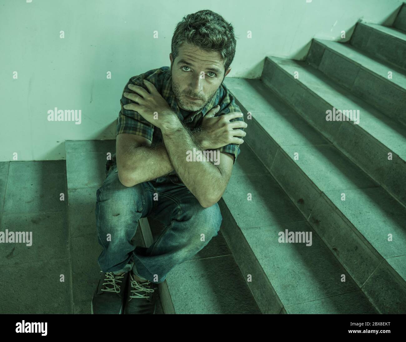 dramatic lifestyle portrait of young depressed and sad man sitting ...