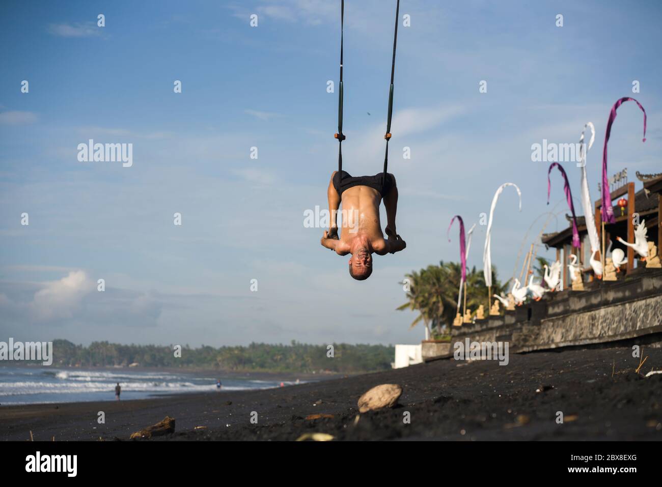 outdoors portrait of man practicing aero yoga workout at the beach ...