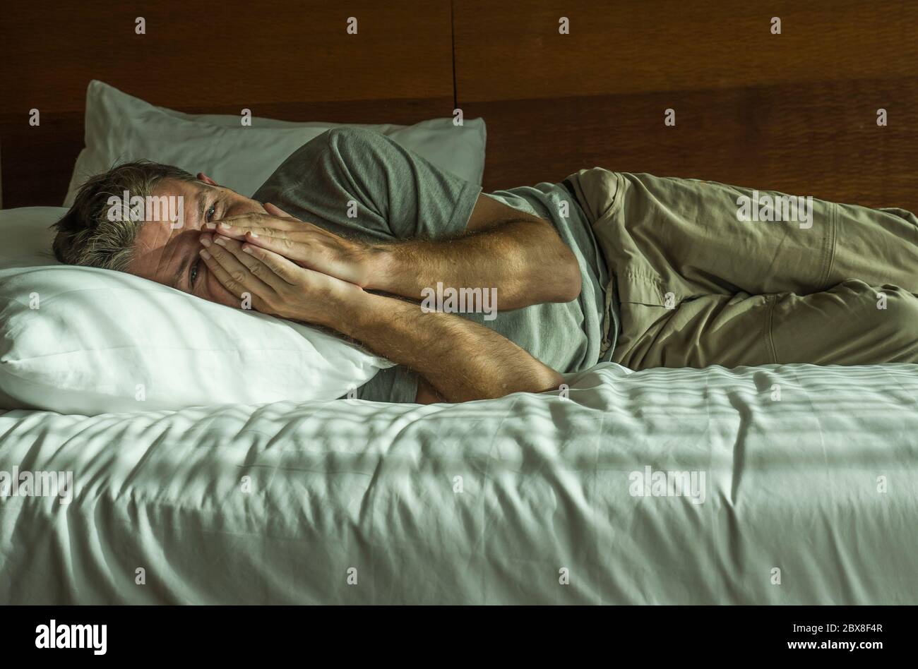 dramatic lifestyle portrait of young attractive sad and depressed man ...