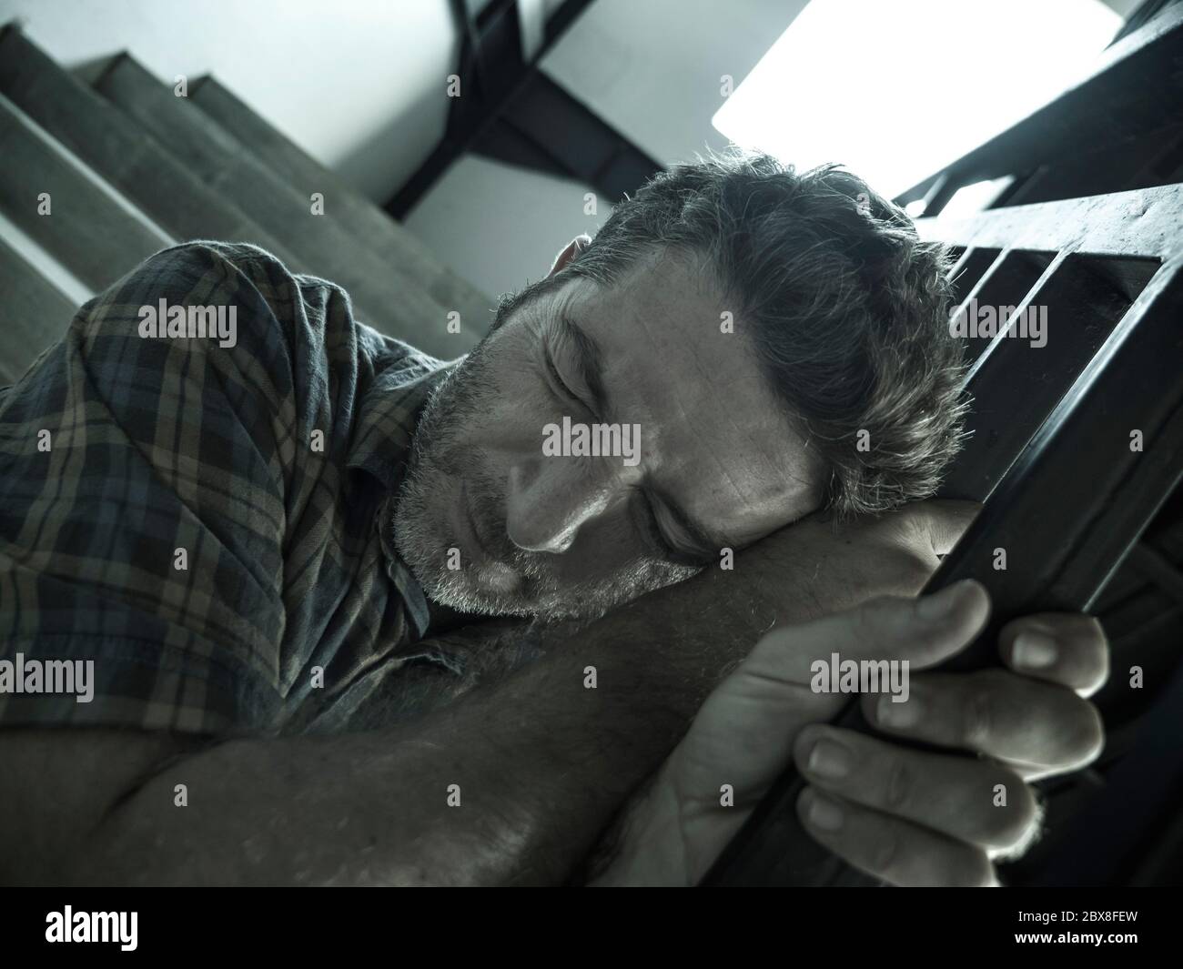 dramatic portrait of young depressed and paranoid man sitting outdoors ...