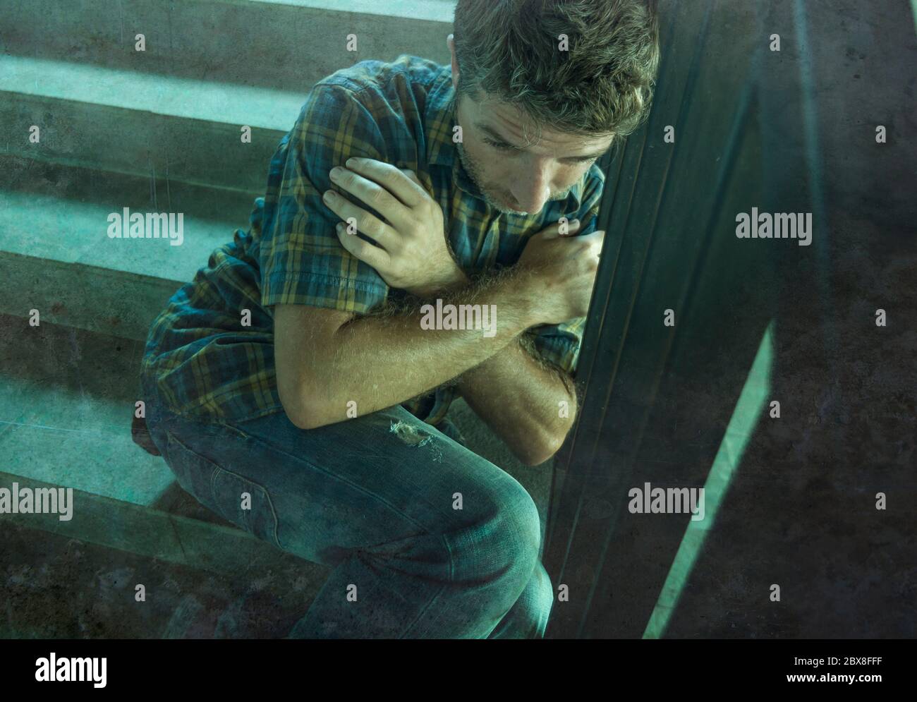 dramatic portrait of young depressed and paranoid man sitting outdoors ...