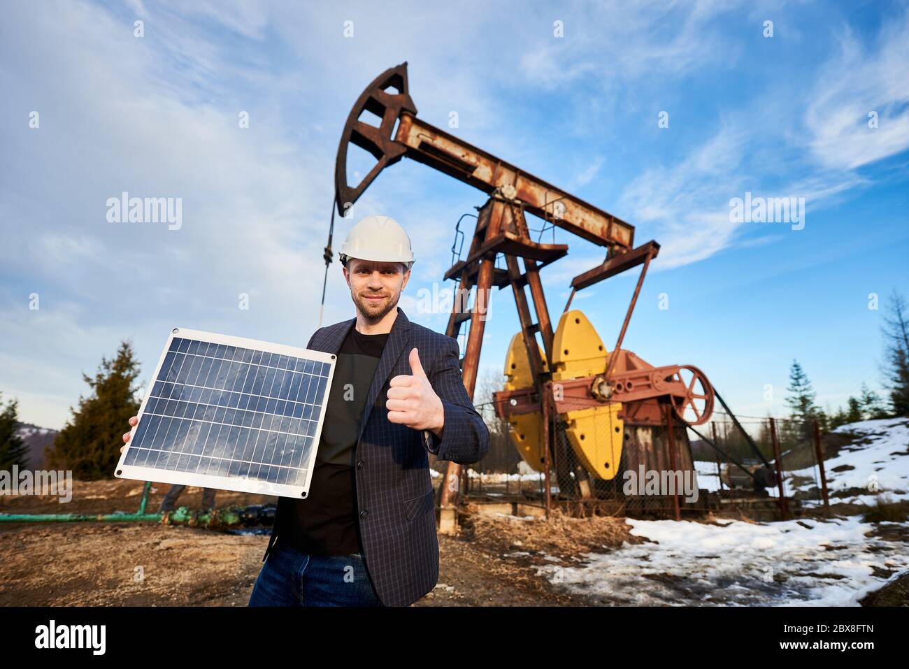 Businessman wearing sport coat, jeans and white helmet, holding mini ...