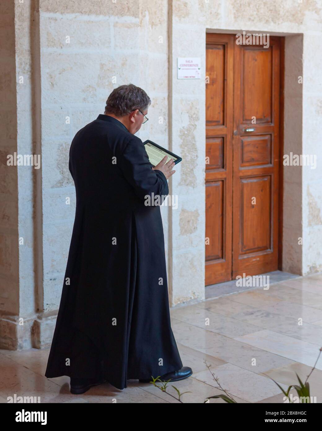 Capurso, Italy - 25/08/2019: A religious prays reading from a digital ...