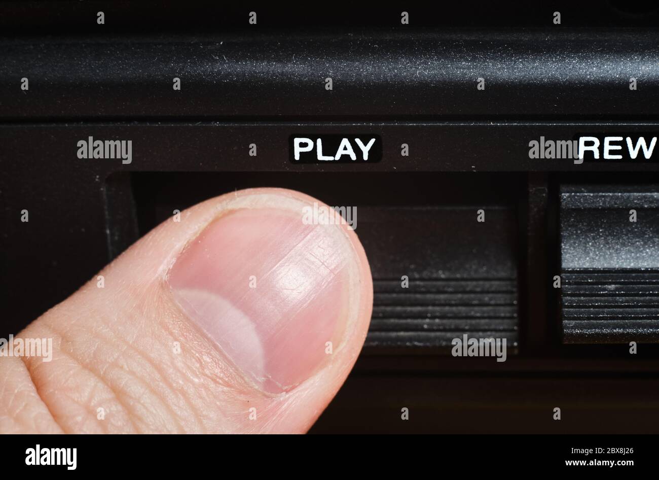 Finger pressing the play button on cassette player Stock Photo - Alamy