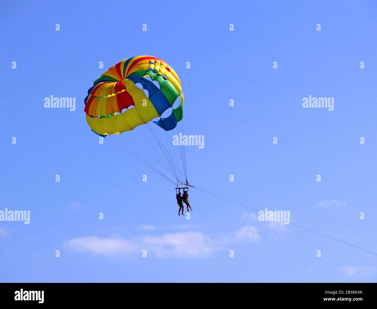 Parasailing beach adventure. Tourist attraction. Parachute in blue sky ...