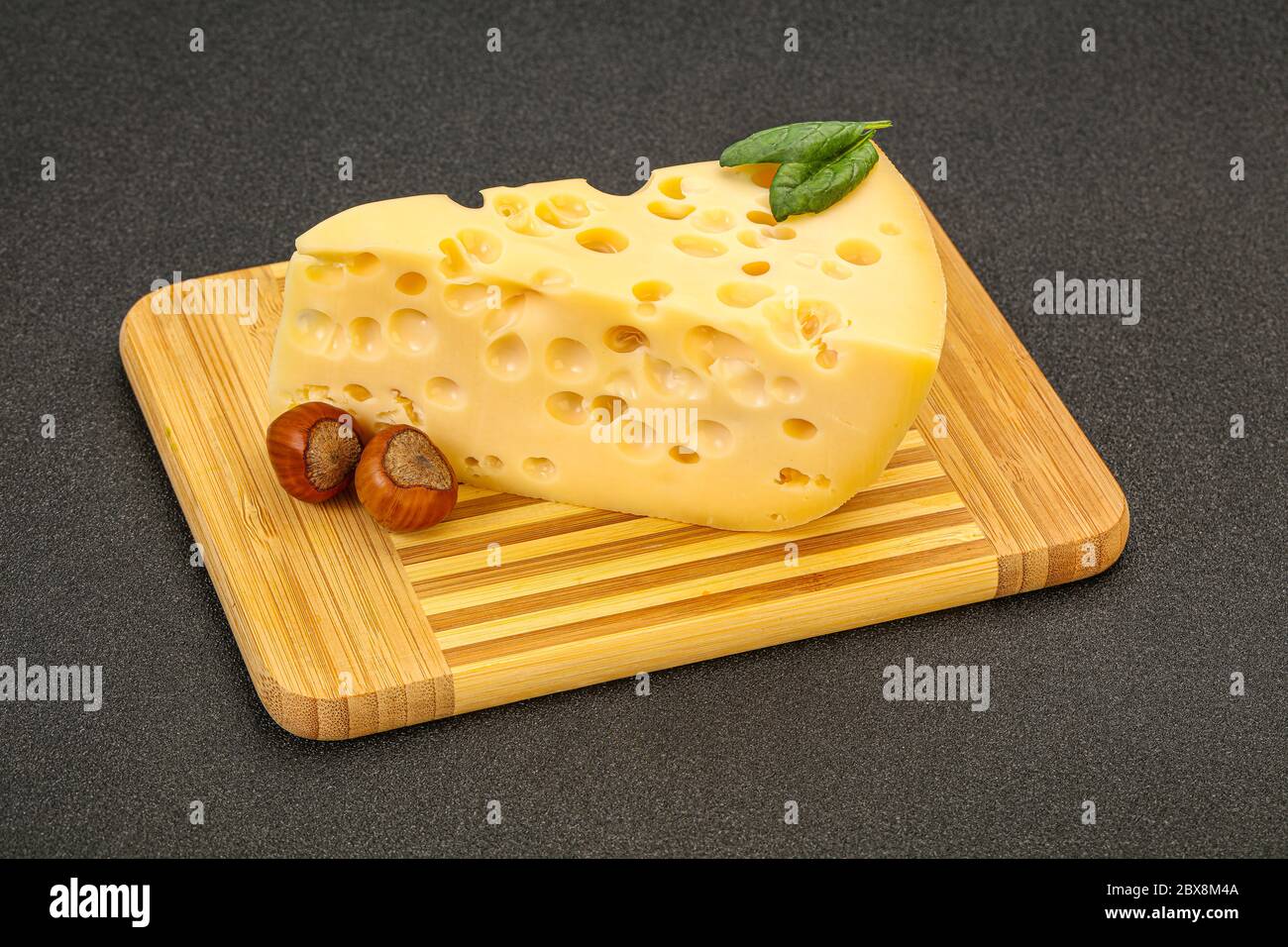 Maasdam cheese - dairy yellow triangle with holes Stock Photo - Alamy