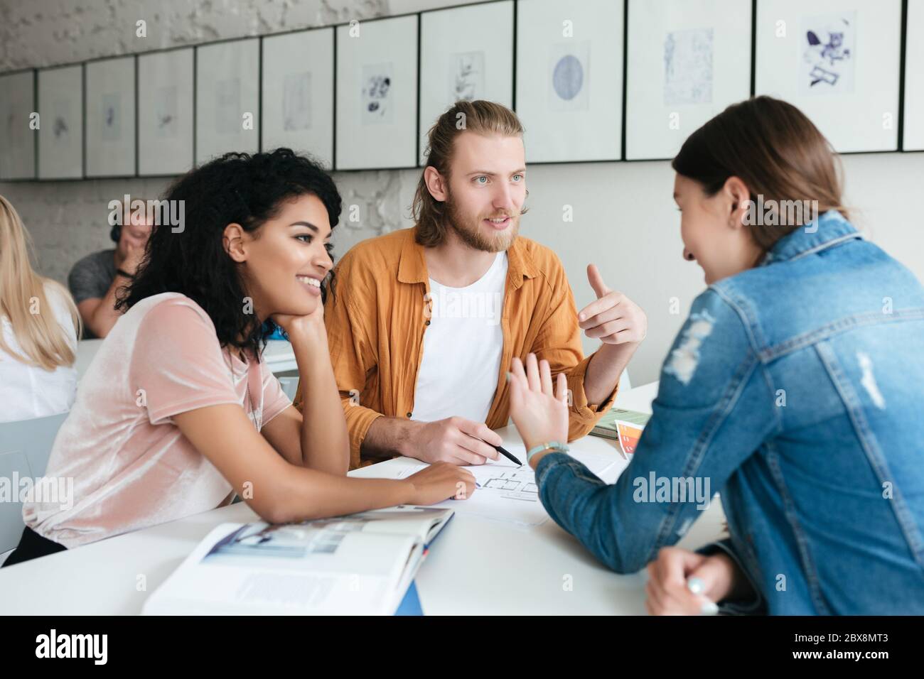 Young man and two girls working together in the office. Group of ...