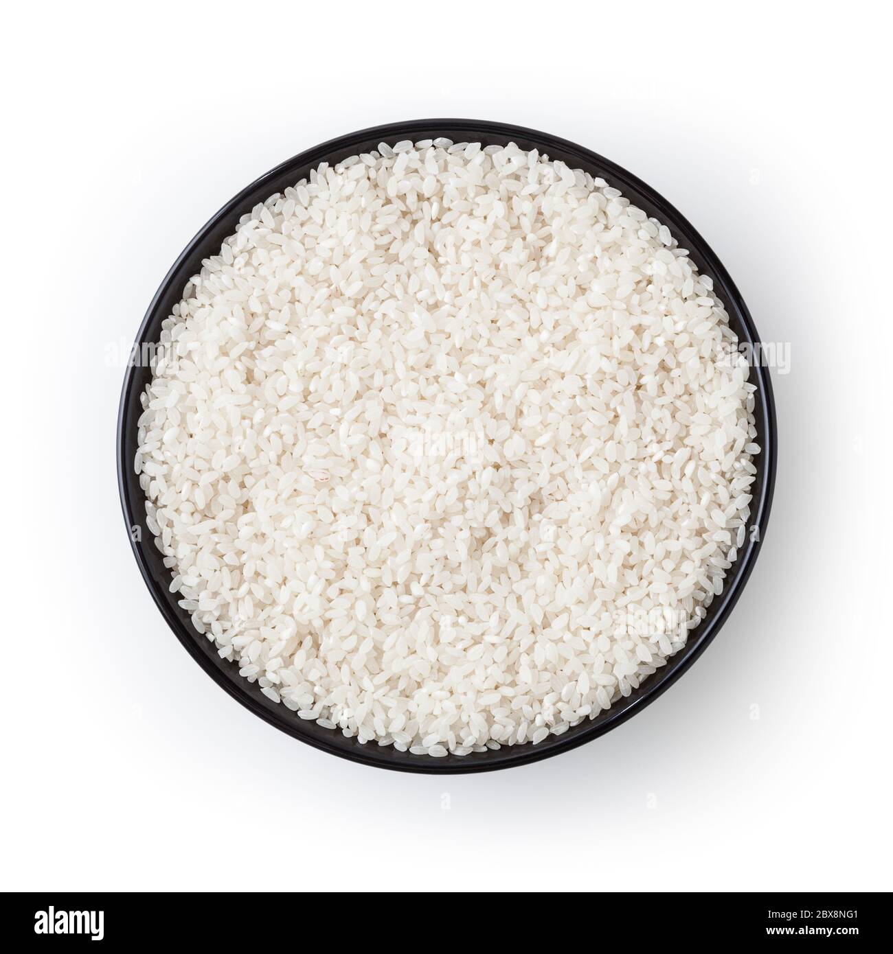 Uncooked round rice in black bowl isolated on white background with ...