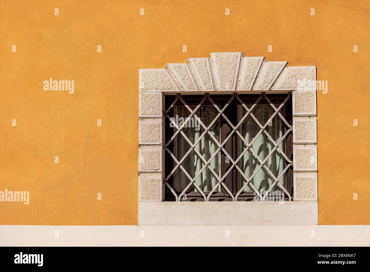 Small window with wrought iron security bars on an orange and white ...
