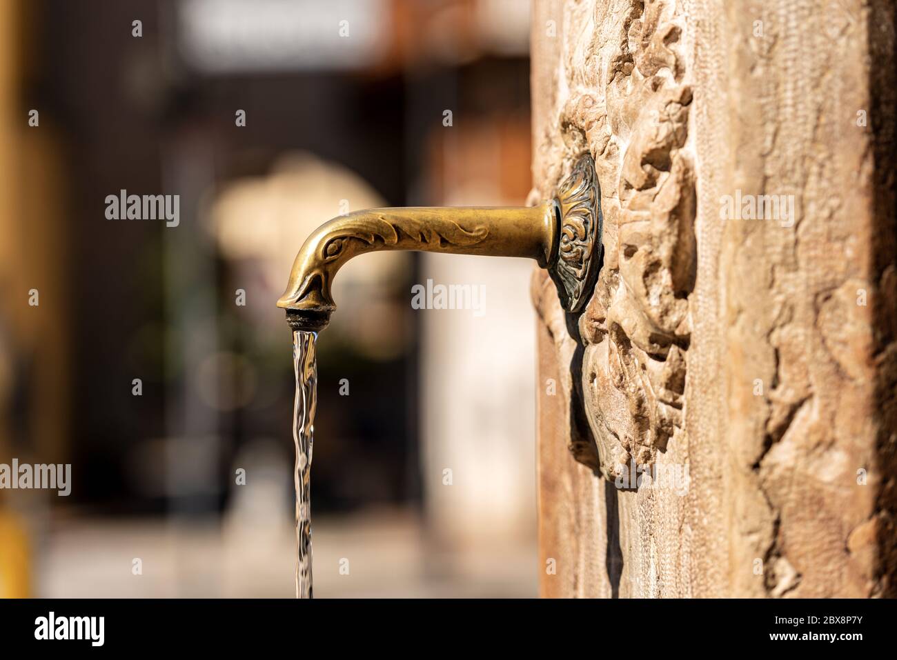 Extreme close-up of fresh water flowing from an outdoor faucet in the ...