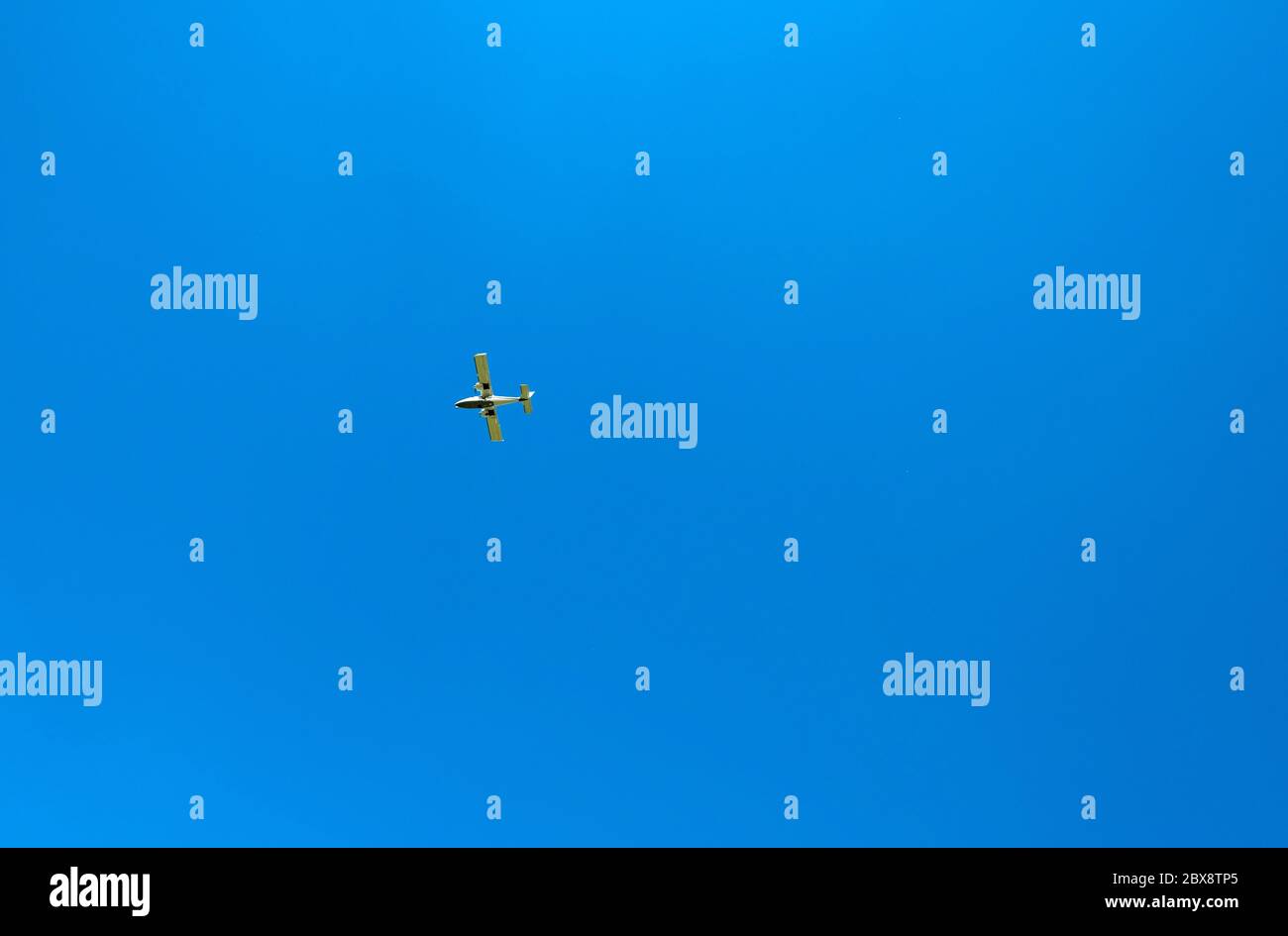 Small light aircraft flying against a deep blue sky Stock Photo - Alamy