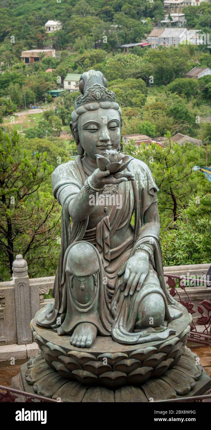 Buddhist Deva statue offering a flower to the Tian Tan Big Buddha ...