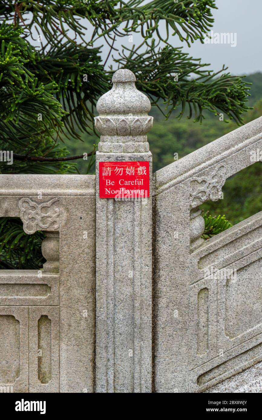 Small red sign on a concrete post with chinese writing translating to ...