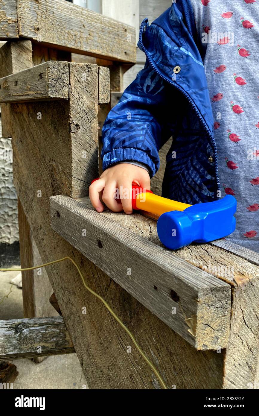 Little boy holding toy hammer. Educational games concept Stock Photo ...