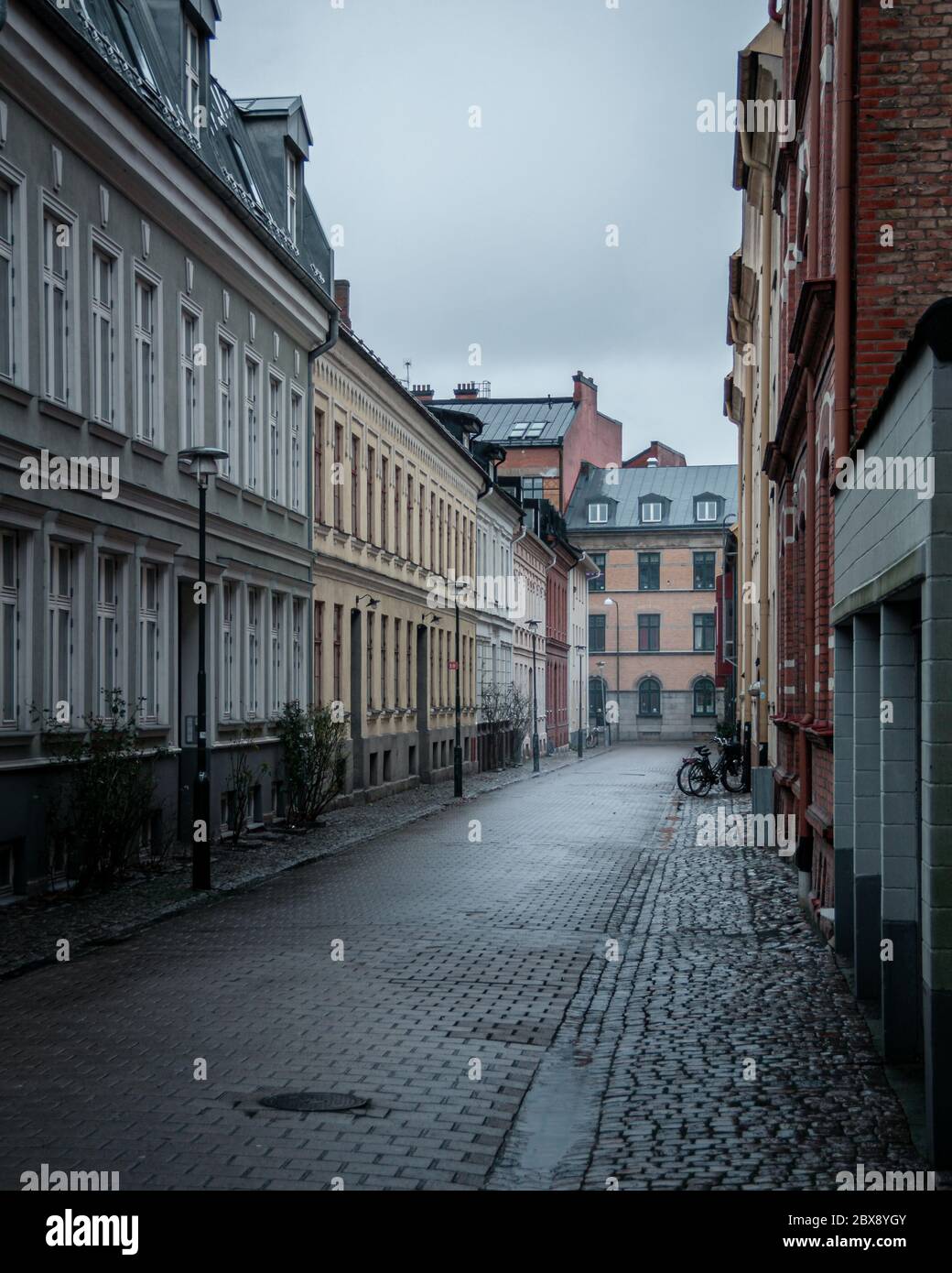 An empty cobblestoned street bordered with old colorful houses on a ...